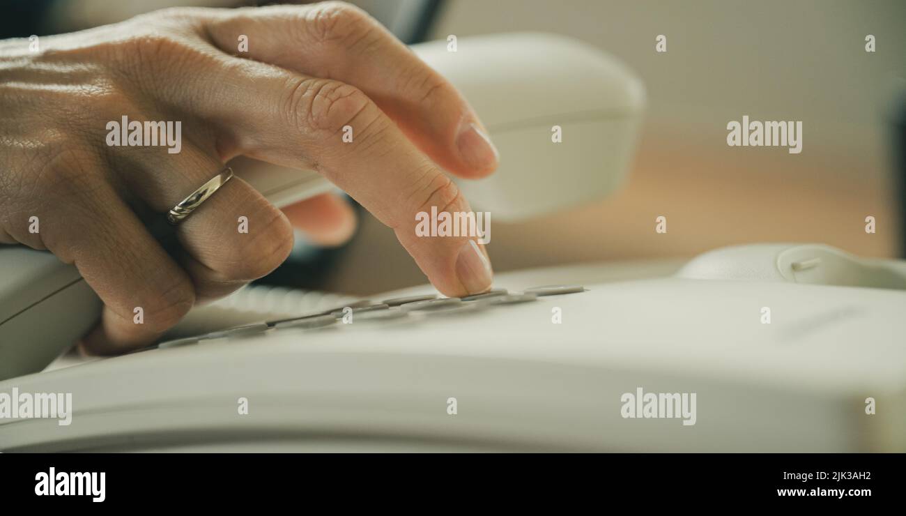Low angle closeup view of a caucasian female hand holding telephone ...