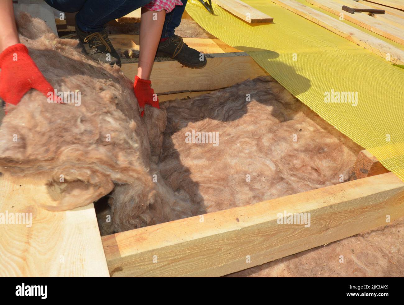 Roofing insulation. A roofing contractor is installing mineral wool ... Roofing insulation. A roofing contractor is installing mineral wool ...