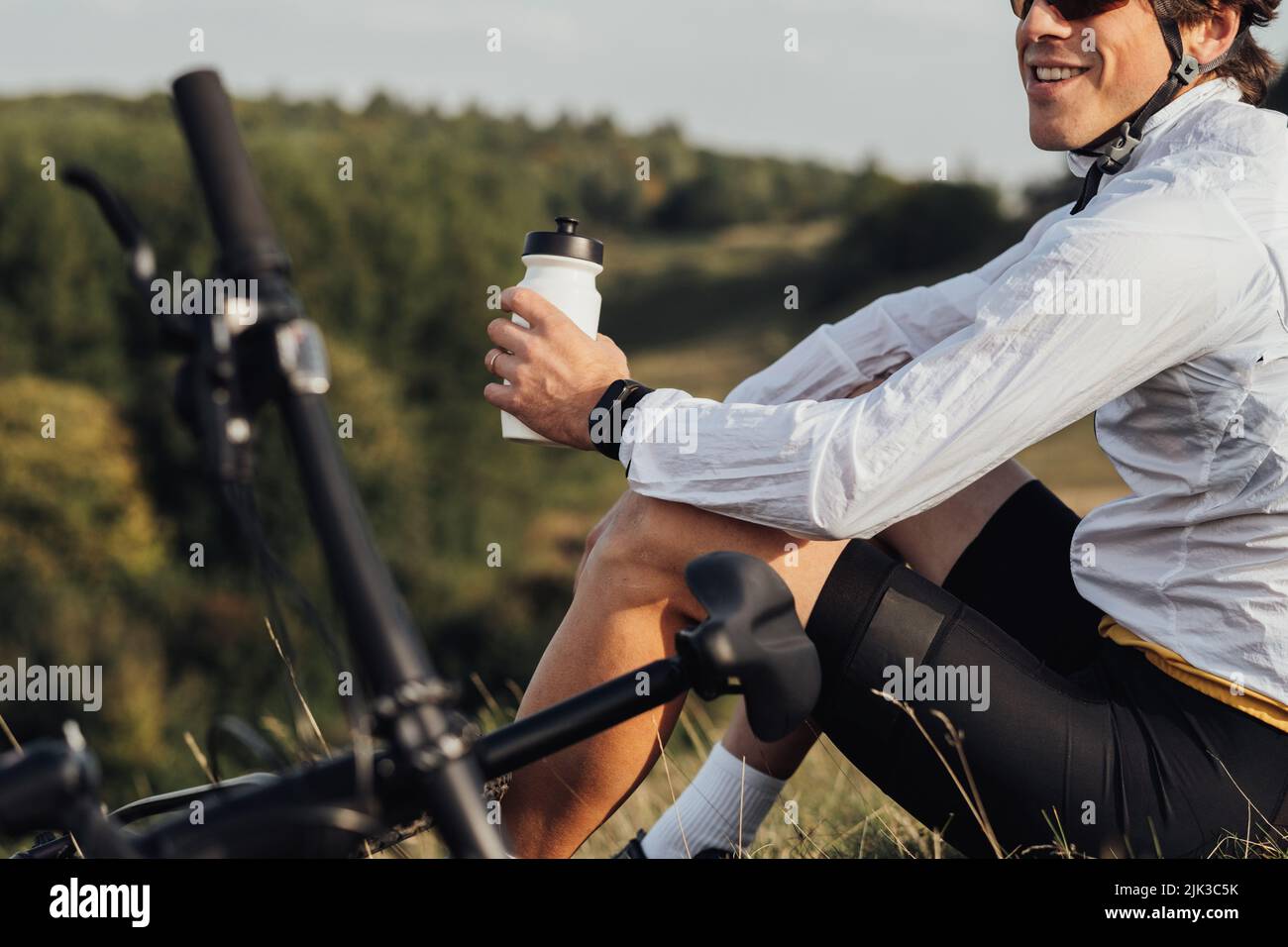 Professional Male Cyclist Drinking Water from Bottle, Man Sitting Near ...