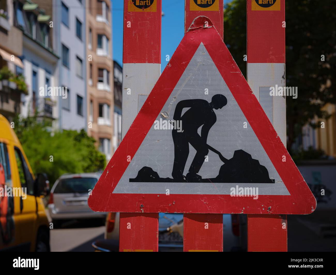 Man At Work Sign On Road. Construction warning sign on blur traffic ...