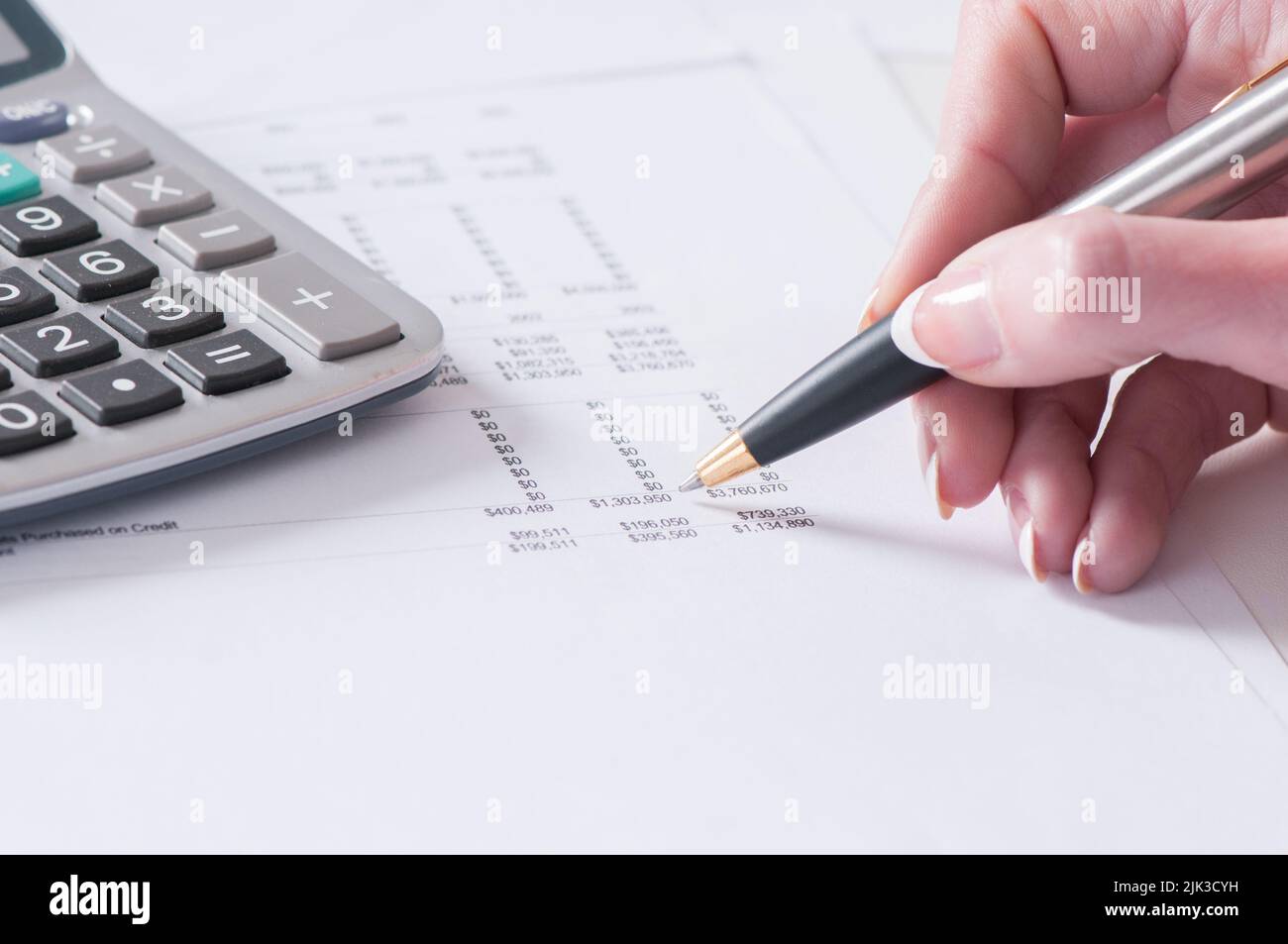 Spreadsheet with hand holding pen and calculator in business stock ...