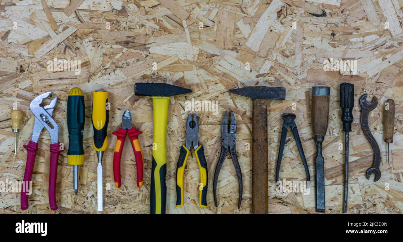 Old rusty tools near modern tools on the OSB sheet. Concept: equipment ...