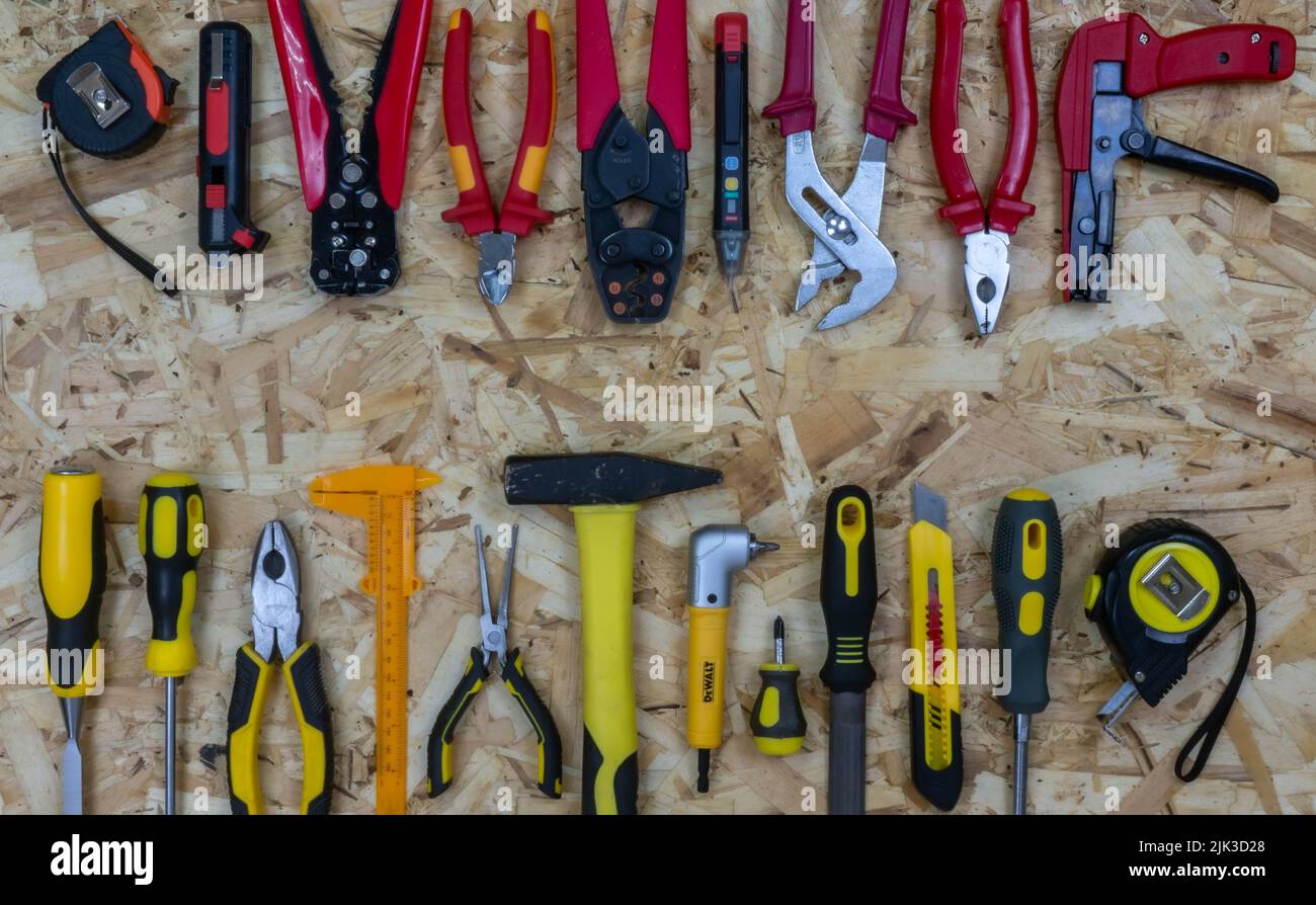 A red construction tools opposite a yellow working tools on a osb plate ...