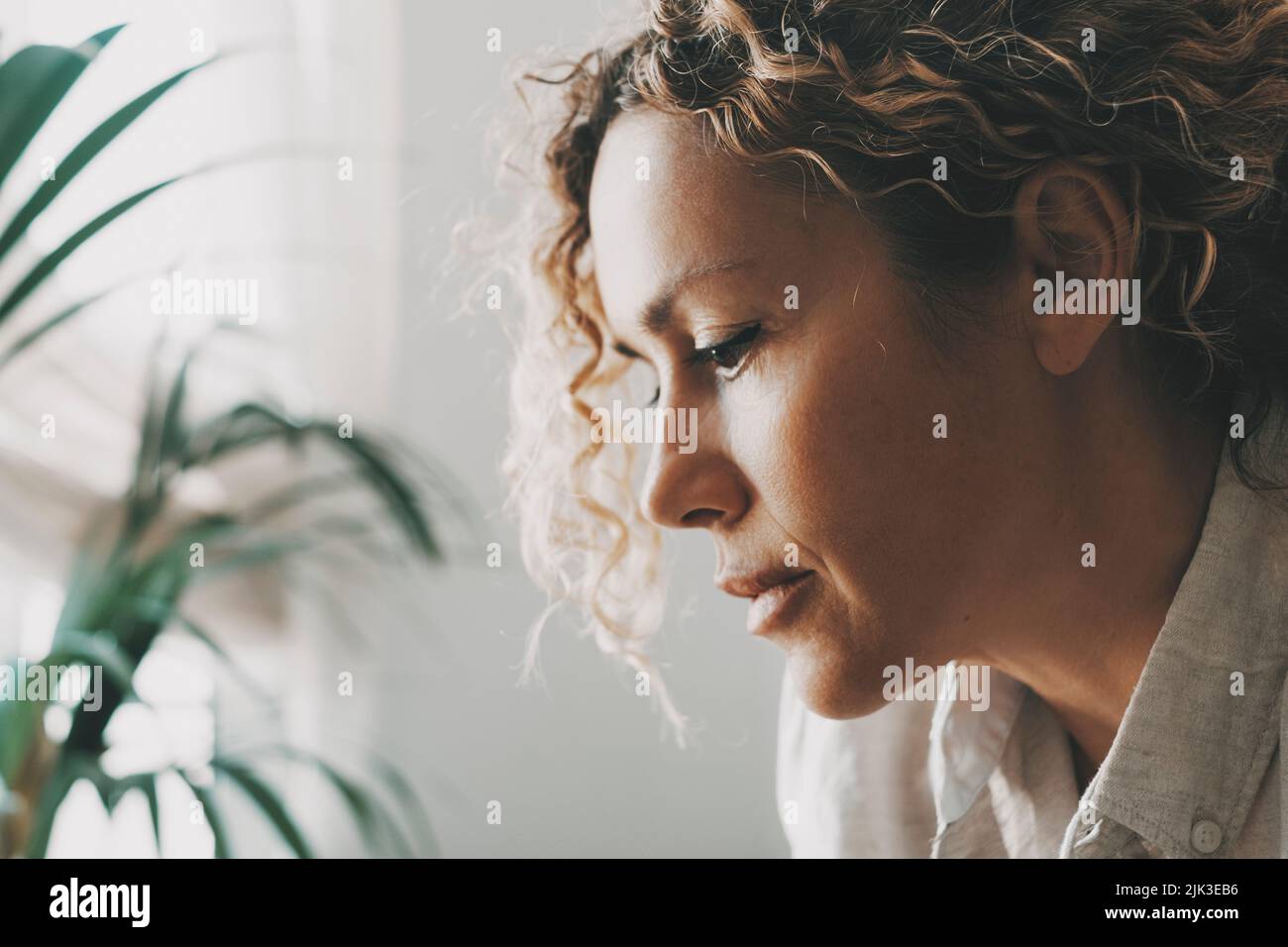 Close up portrait of woman with worried expression looking down ...