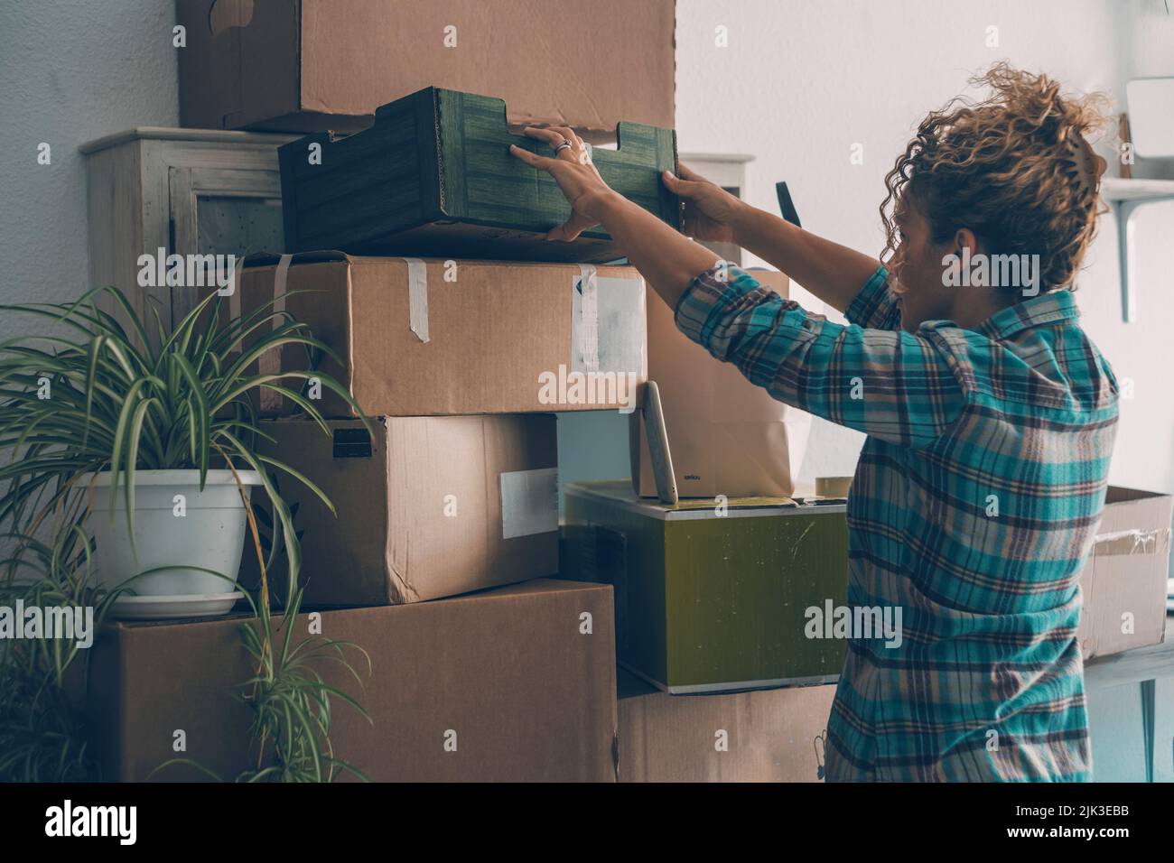 Side view of a woman and carton box cardboards inside a new apartment ...