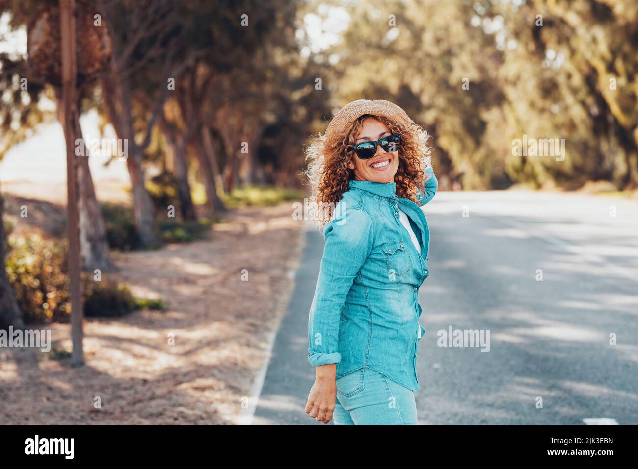 Tourist walk on the road and turn back to smile at her friends enjoying ...