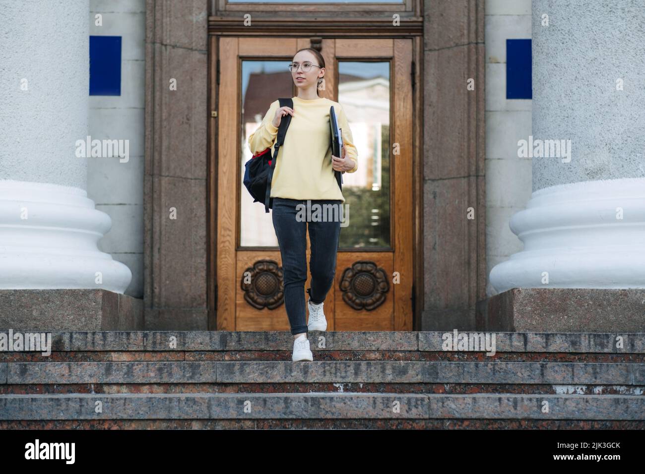 Mixed race college student girl enters the doors of the university ...
