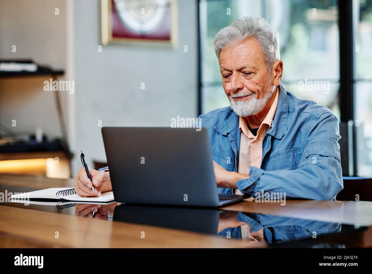 A senior student is sitting in the cafeteria and following online ...