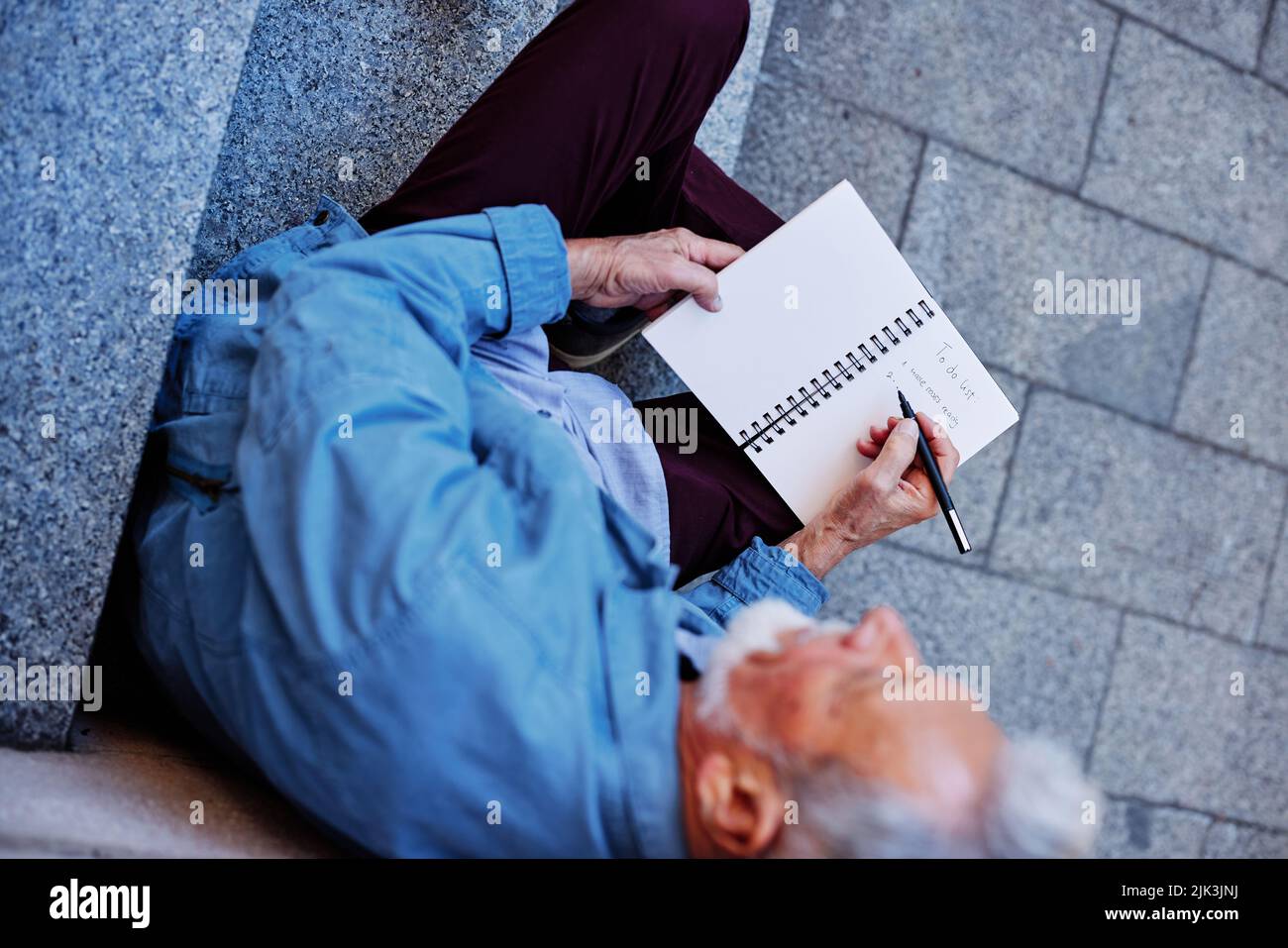 Top view of a senior man sitting outside and writing to do list Stock ...