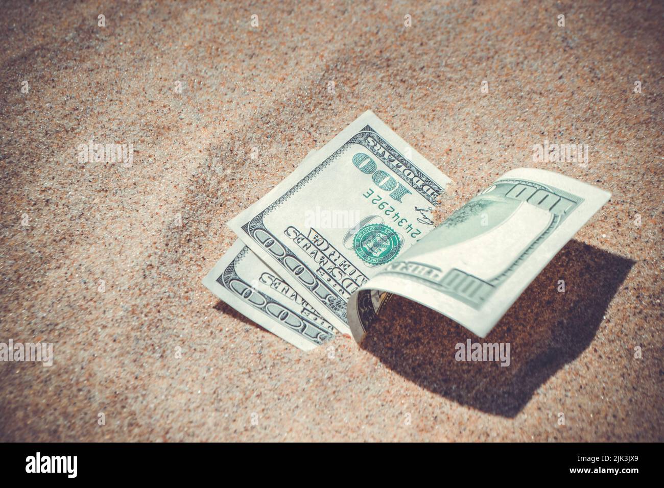Money dollars half covered with sand lie on beach close-up. Dollar ...