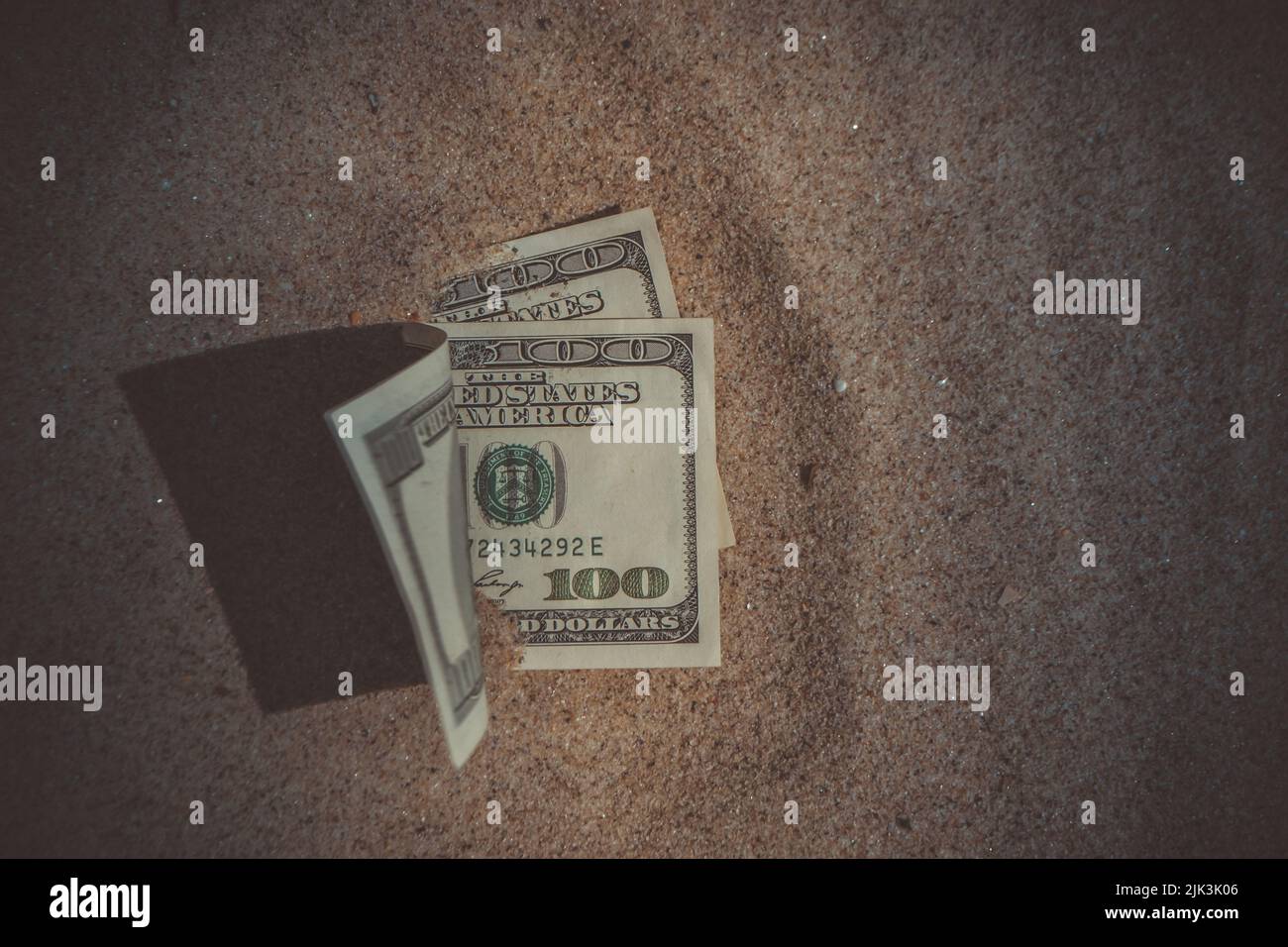Money dollars half covered with sand lie on beach close-up. Dollar ...