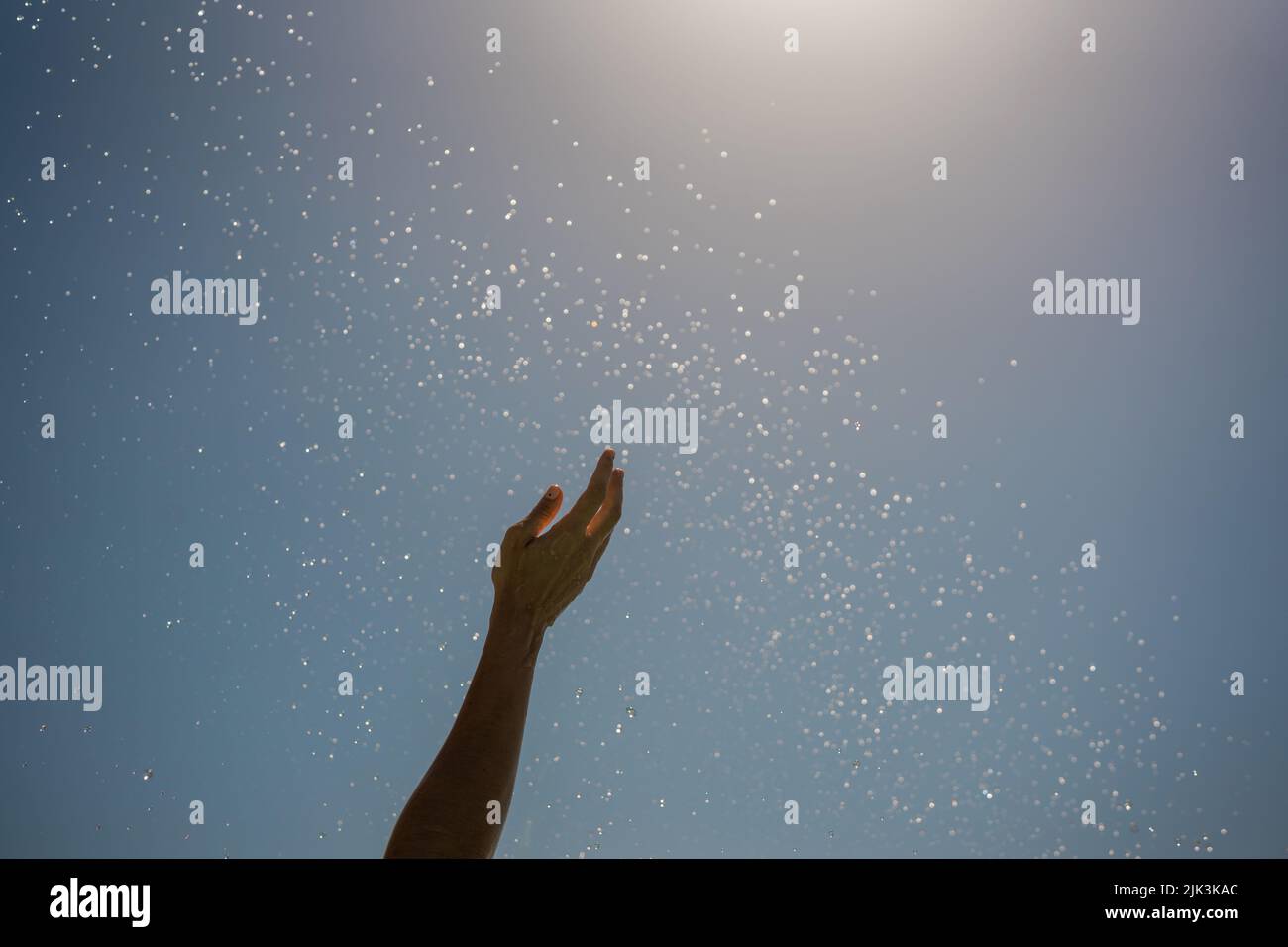 Raised hand splashing water in summer Stock Photo - Alamy