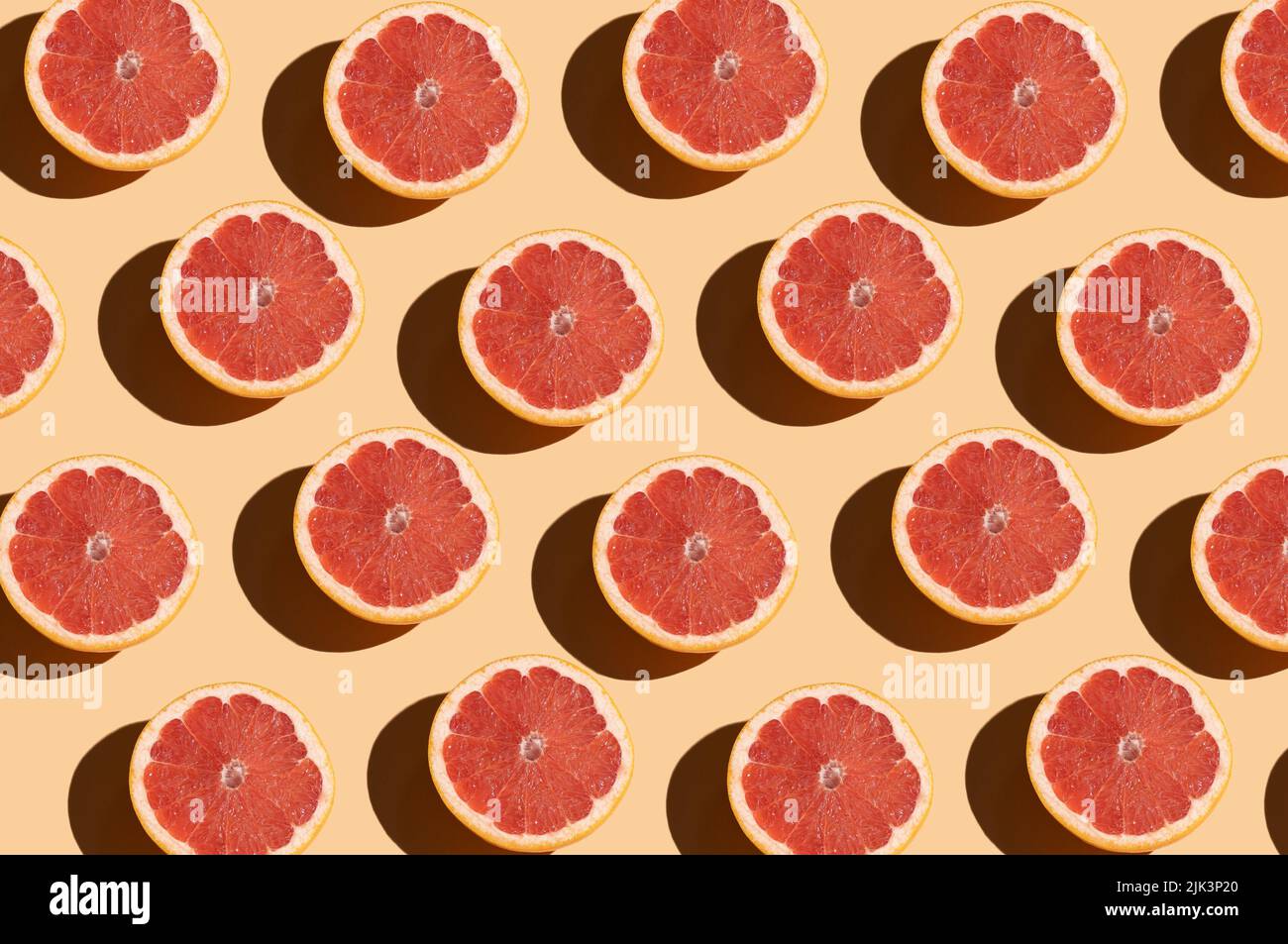 Grapefruit pattern on a beige background. Orange juicy grapefruit cut ...