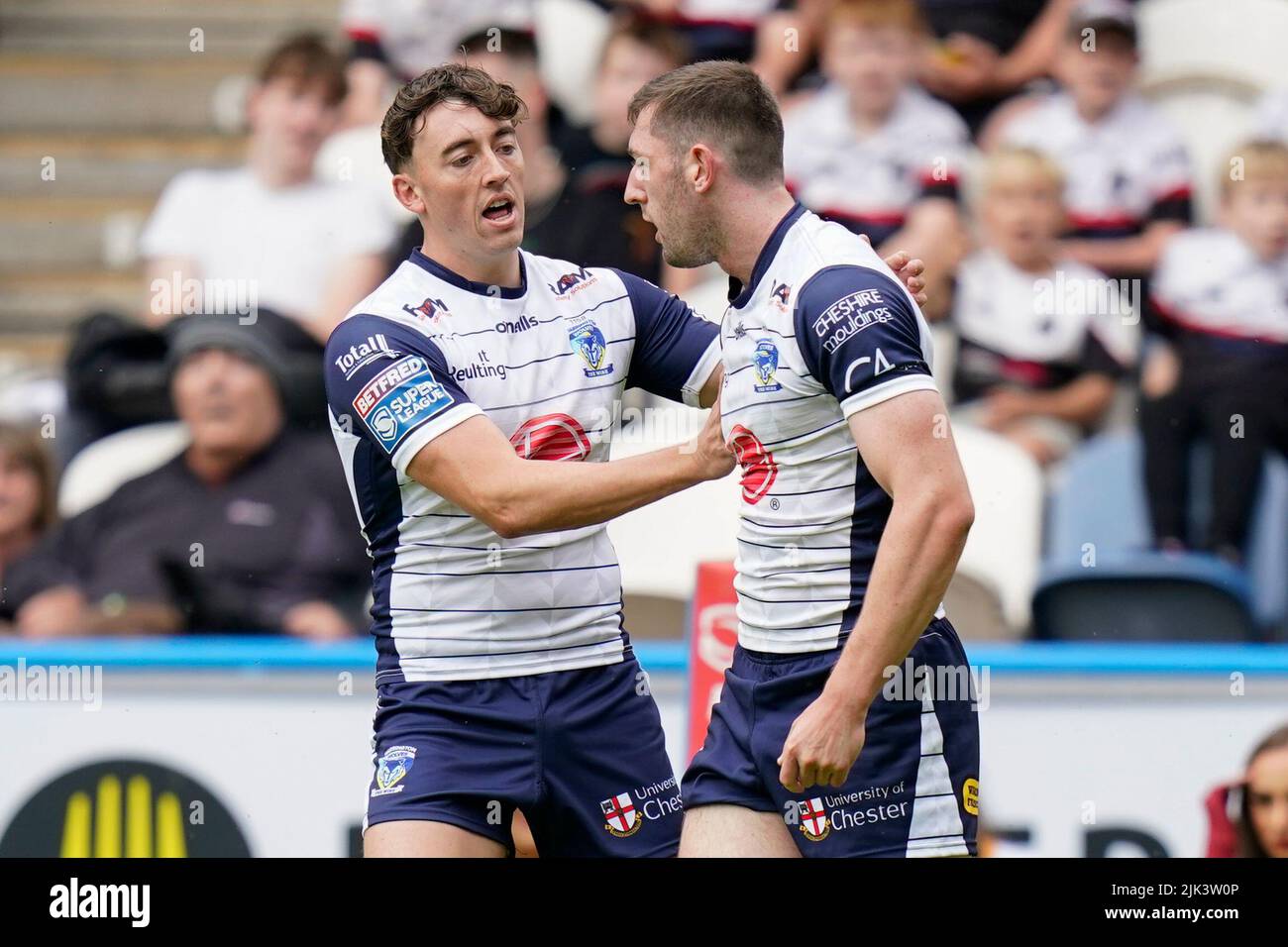 Matty Ashton #5 of Warrington Wolves celebrates with try scorer Jake ...