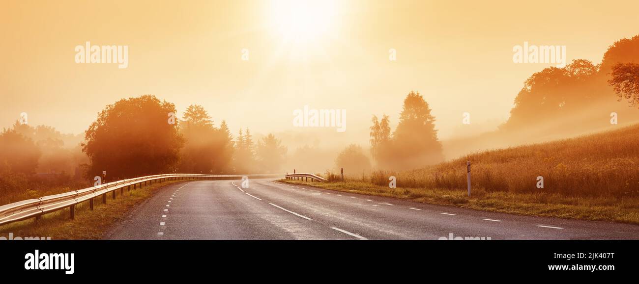 Black asphalt road with dividing line and safety fence in the morning ...