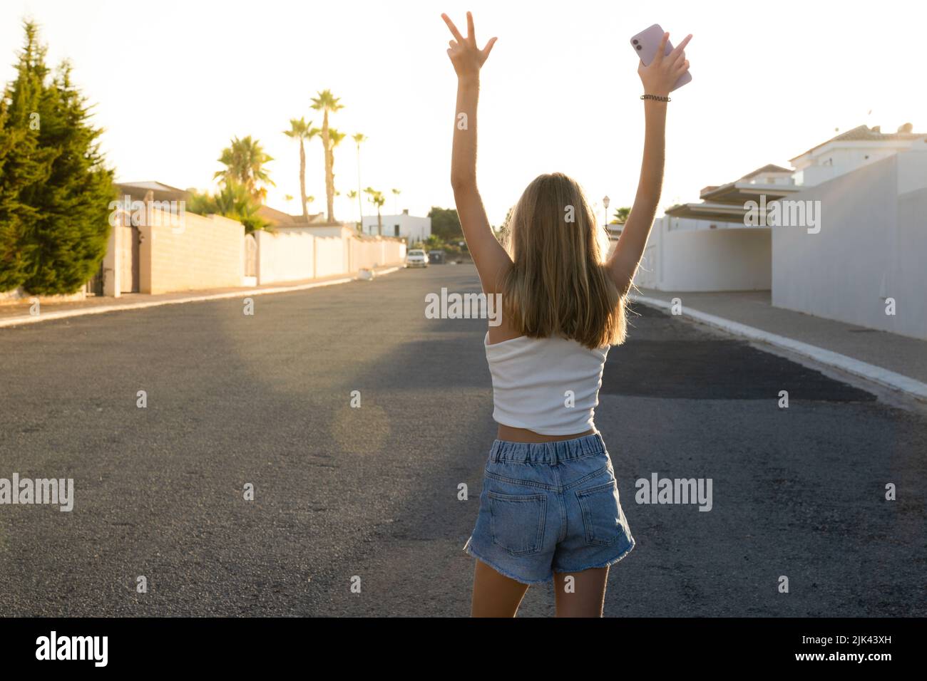 Back view of blonde kid girl 12-13 years old in casual clothing posing ...