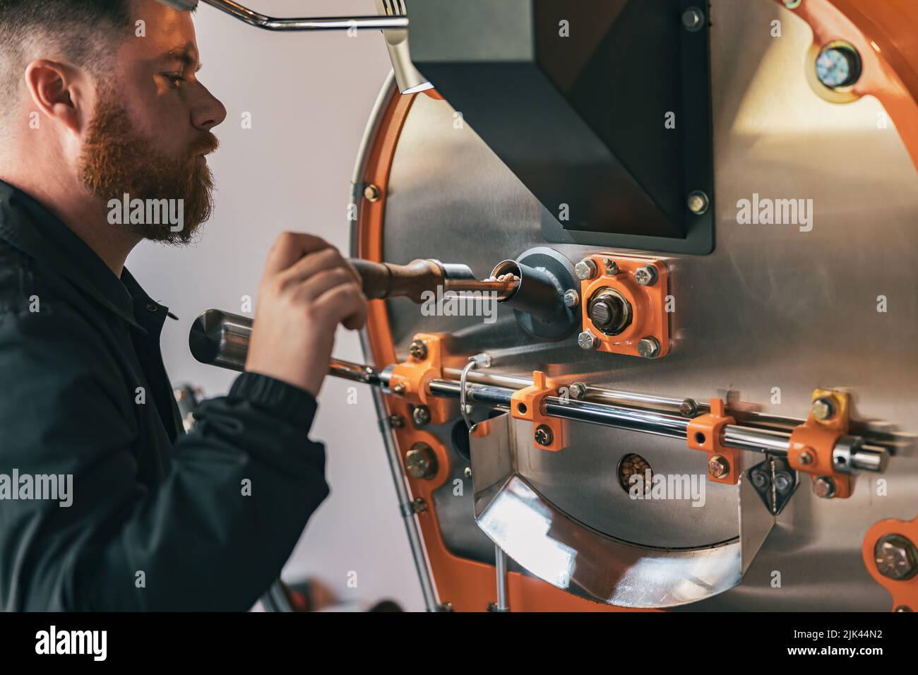 Close up of business owner operating modern coffee bean roasting ...