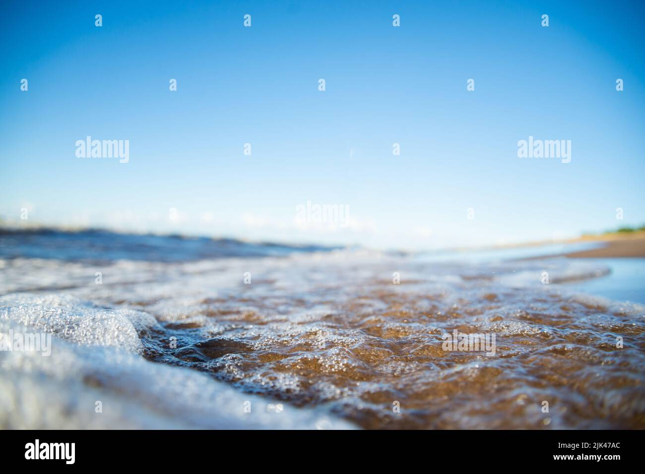 Soft wave of blue ocean on sandy beach. Background Stock Photo - Alamy
