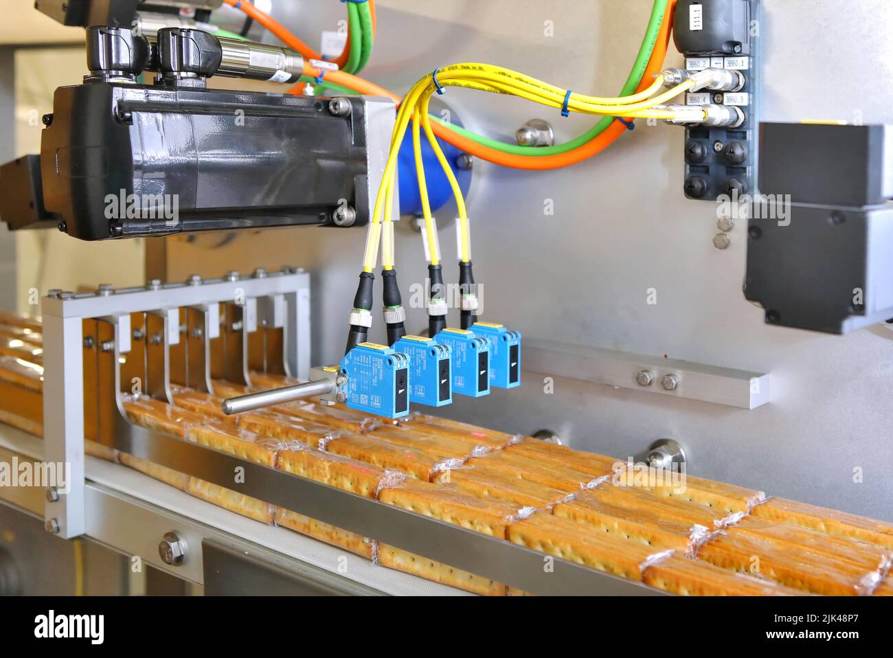 Large biscuit factory. A line of biscuits in a large factory. Packing ...
