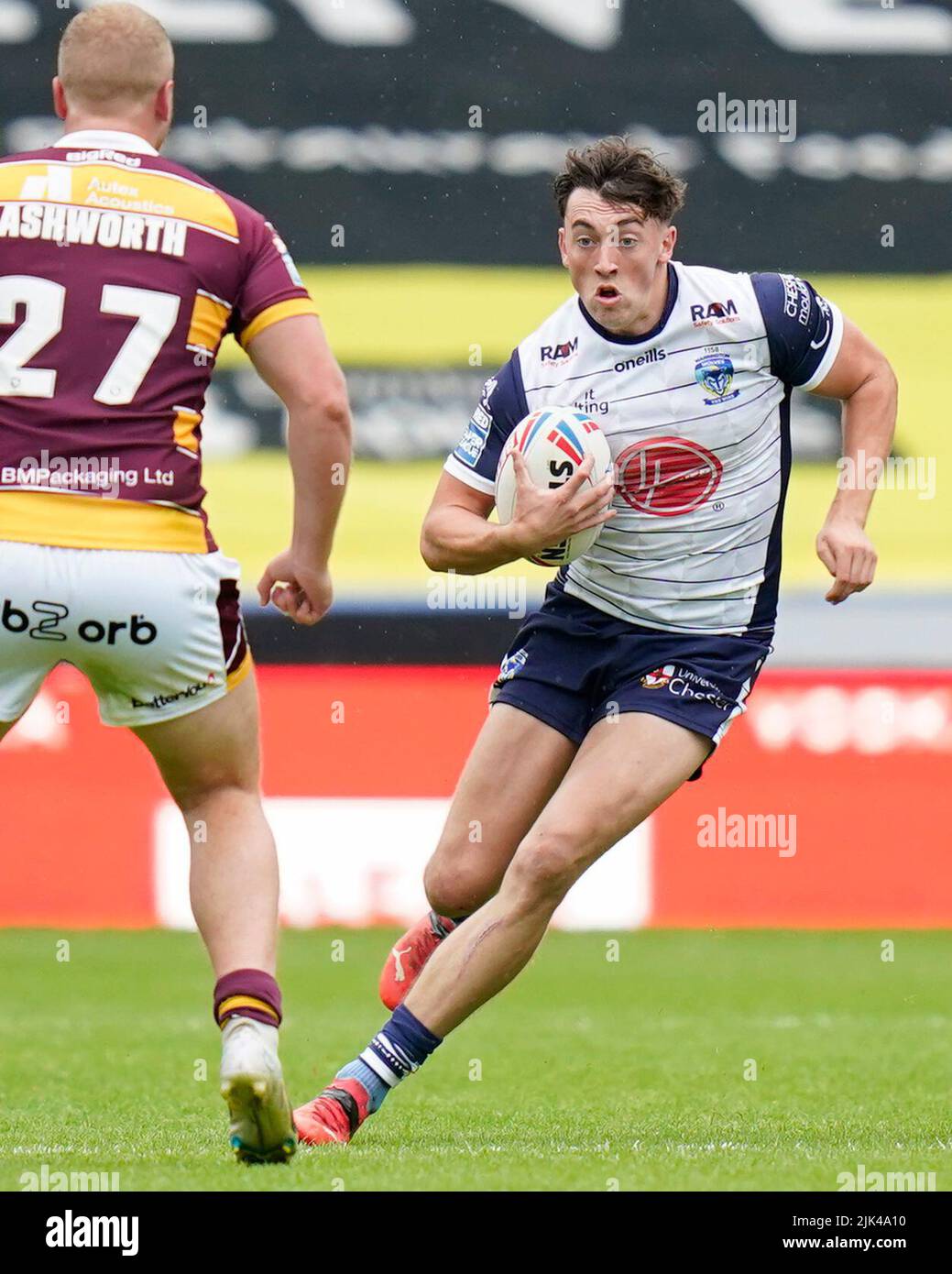 Matty Ashton #5 of Warrington Wolves runs at Jack Ashworth #27 of ...