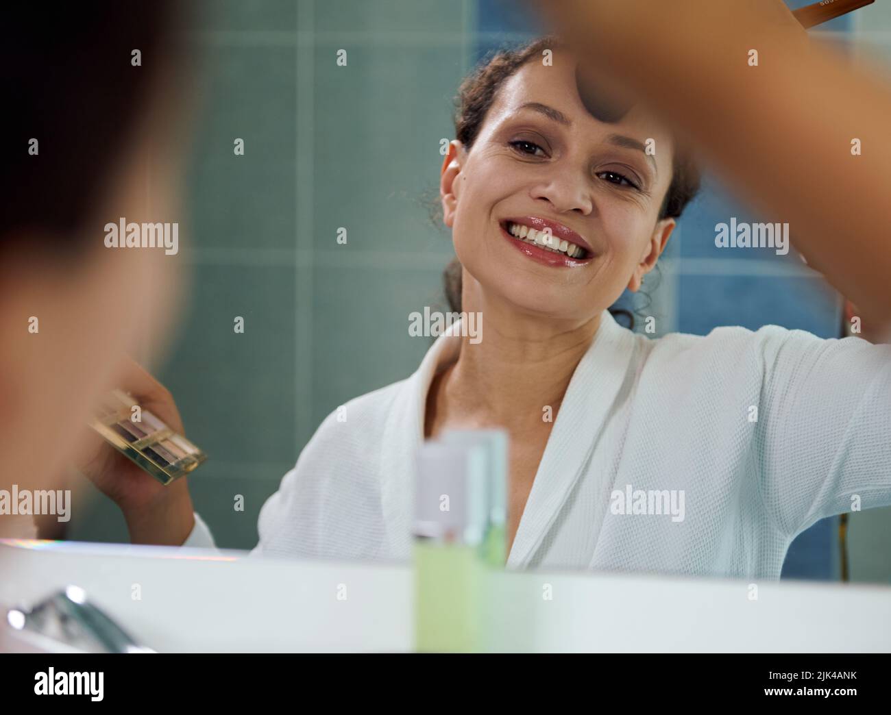 Stunning woman applies mattifying powder on her face, satisfied of her ...