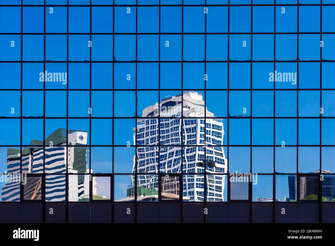 Image of modern buildings reflected in the mirrored facade of a ...