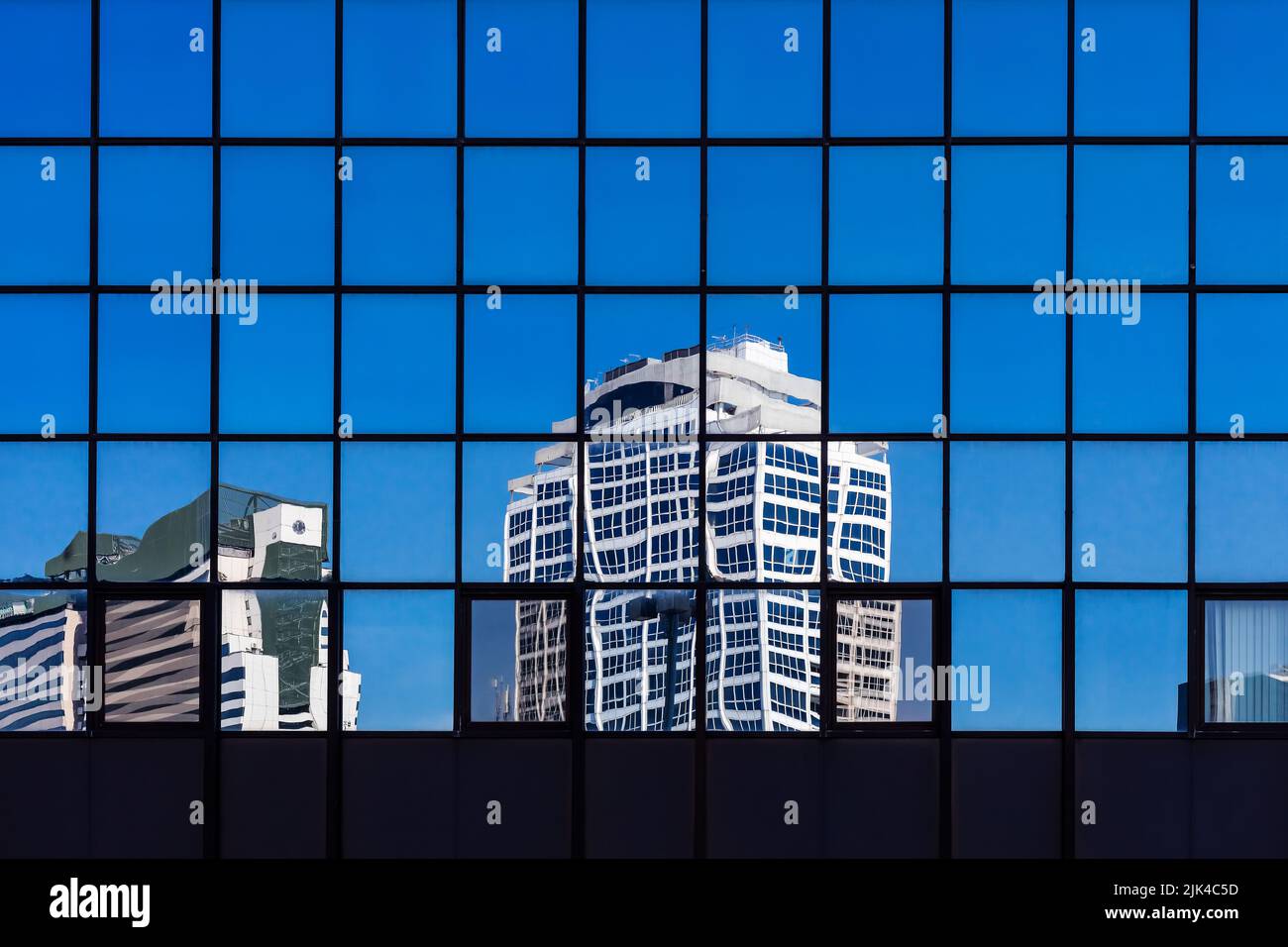 Image of modern buildings reflected in the mirrored facade of a ...