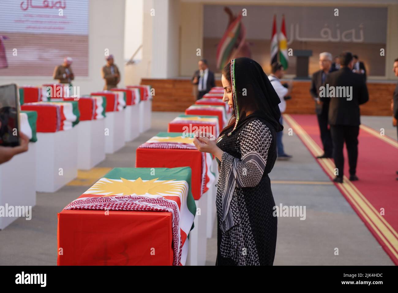 Erbil City, Iraq. 30th July, 2022. A Kurdish woman pays tribute over a ...