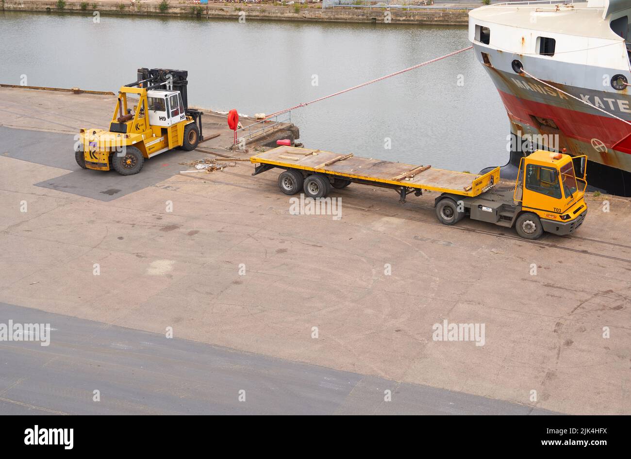 Flatbed lorry next to a docked cargo ship Stock Photo - Alamy