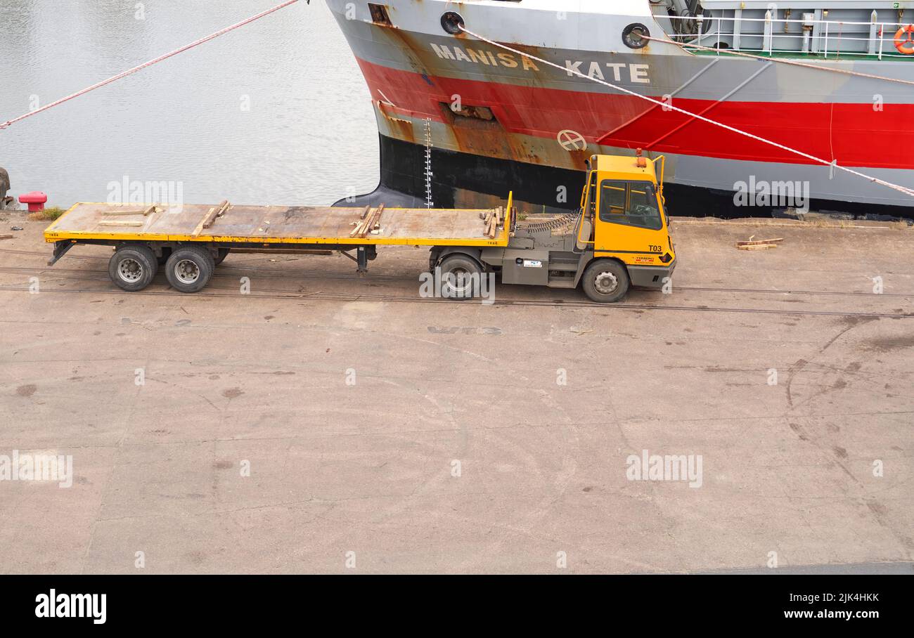 Flatbed lorry next to a docked cargo ship Stock Photo - Alamy