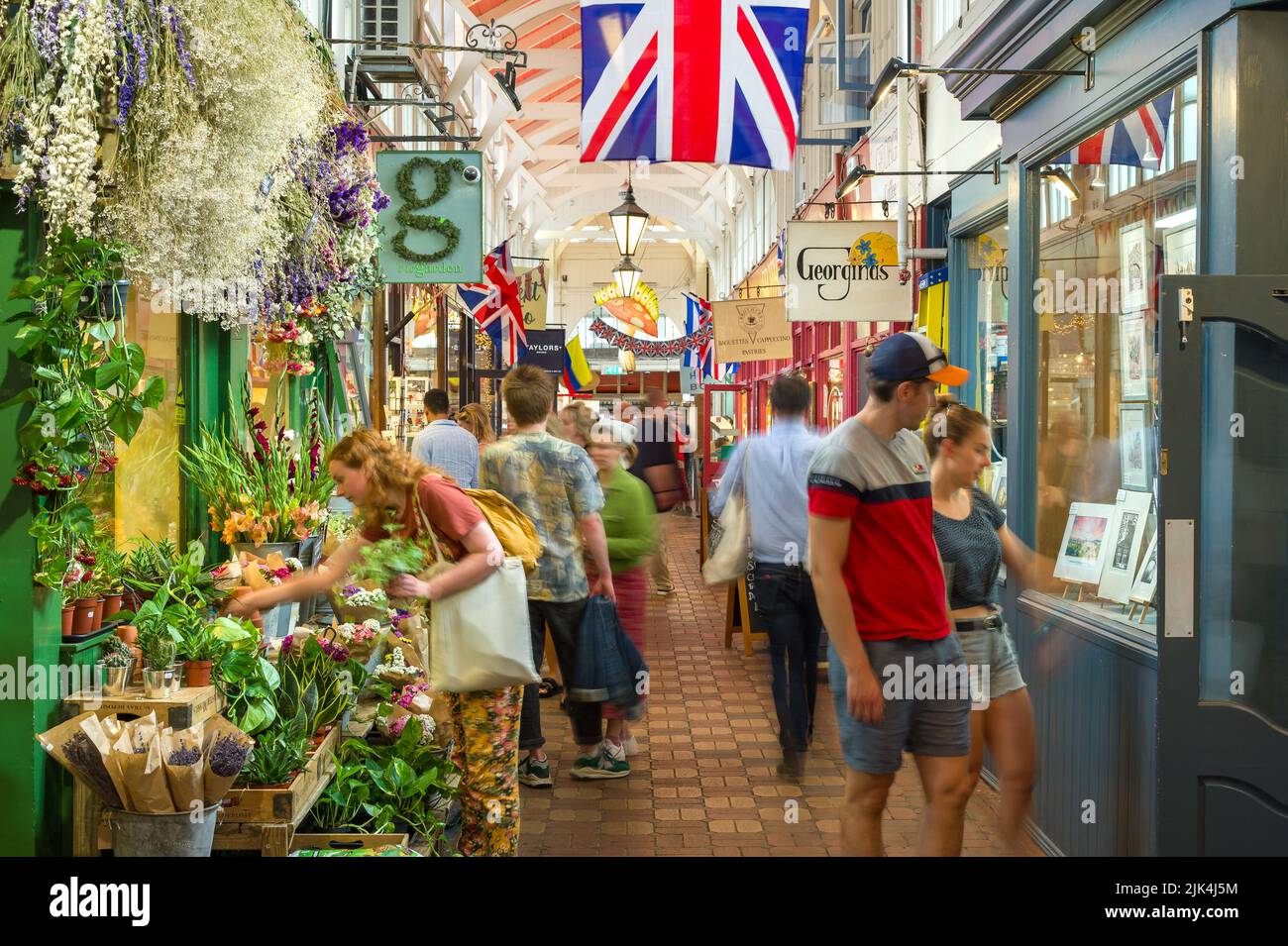Interior of the Covered Market with people walking past shops and a ...