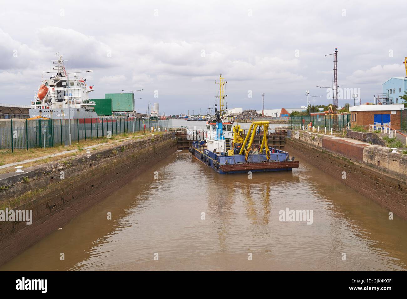Work barge in a sea port canal lock Stock Photo - Alamy