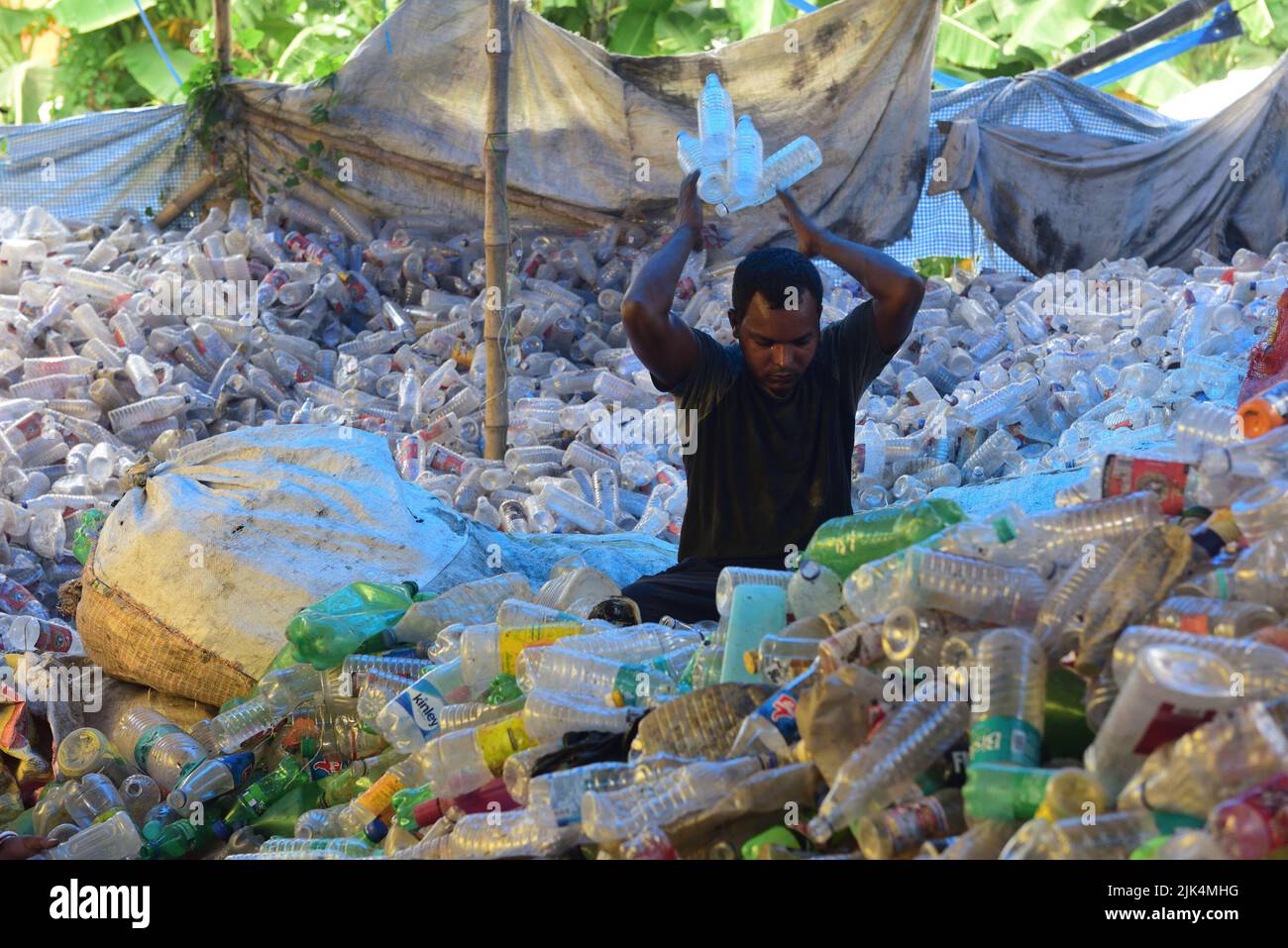 A man seen sorting plastic bottles at a workshop before sending them ...