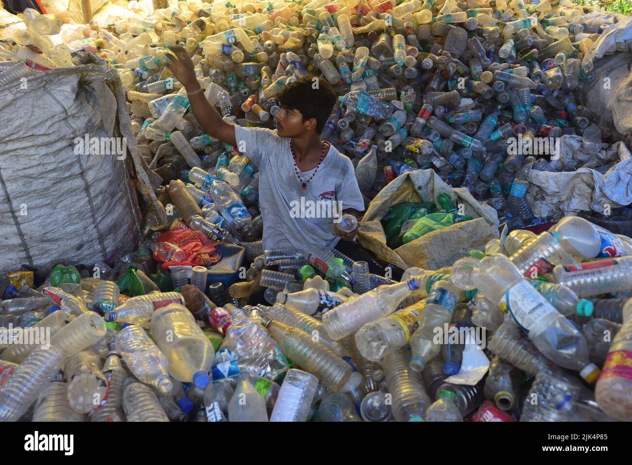 A man seen sorting plastic bottles at a workshop before sending them ...