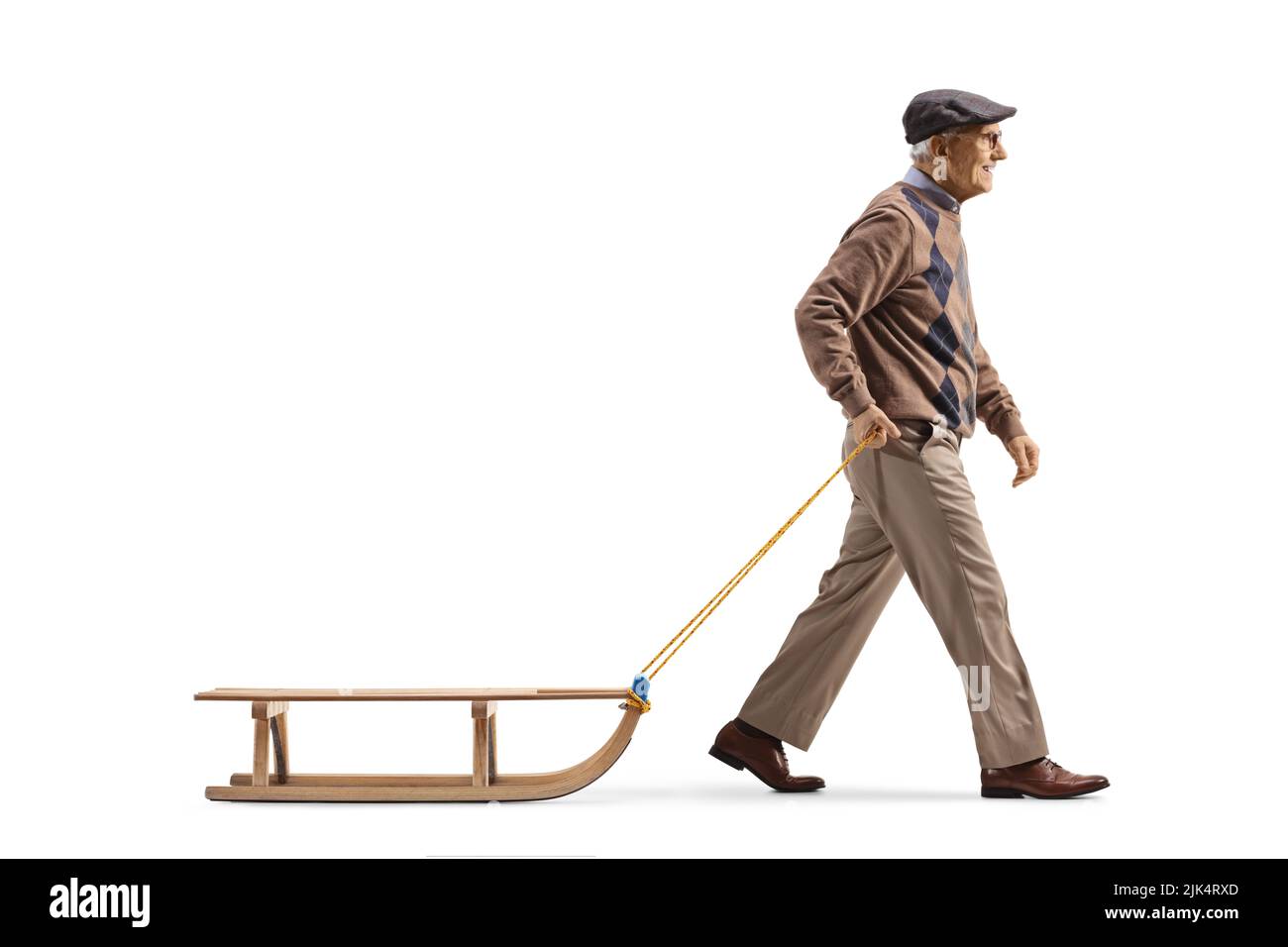 Full length profile shot of a senior man walking and pulling a sled ...