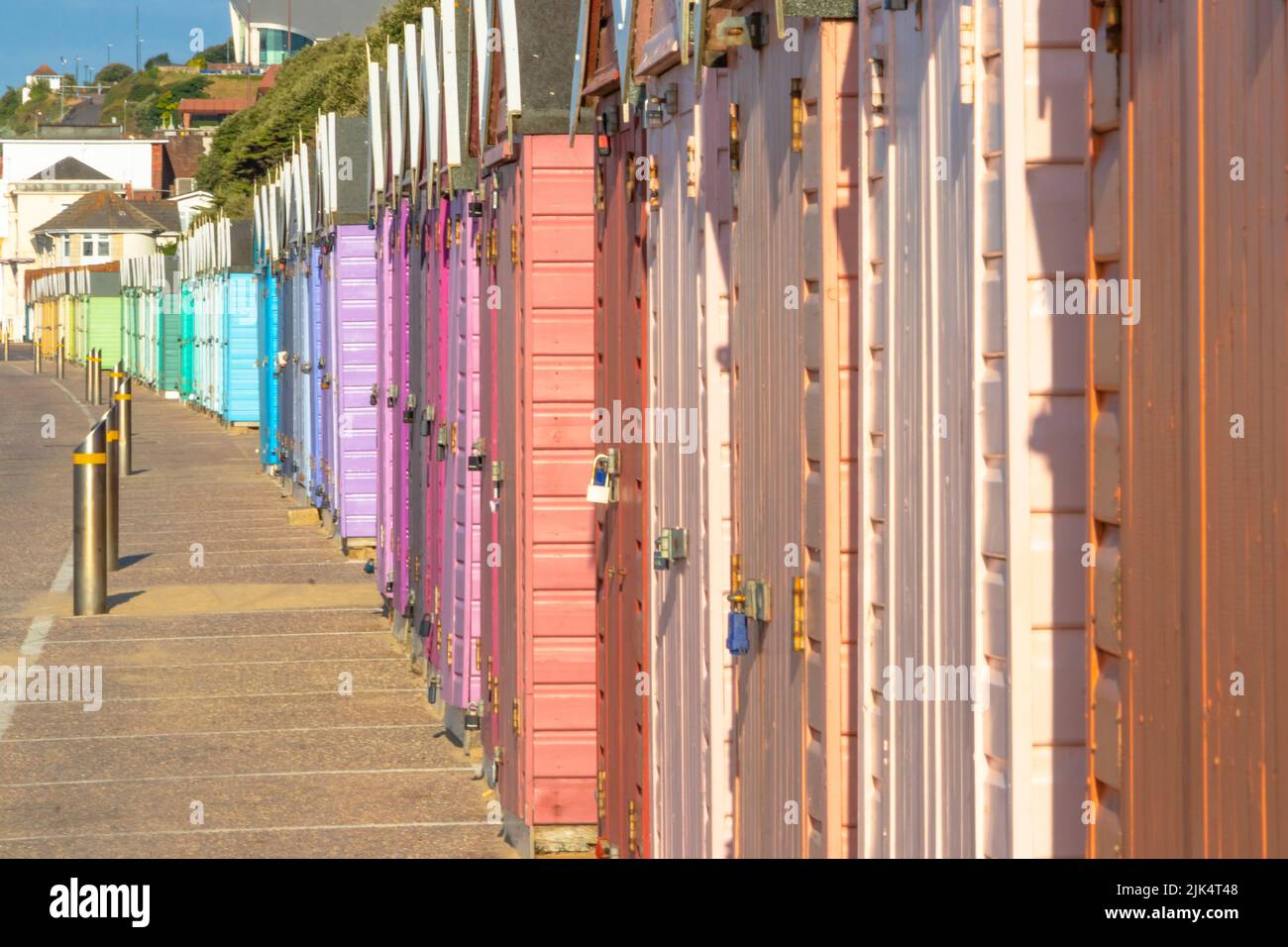 row of multicoloured wooden beach huts by the sea in Bournemouth Dorset ...