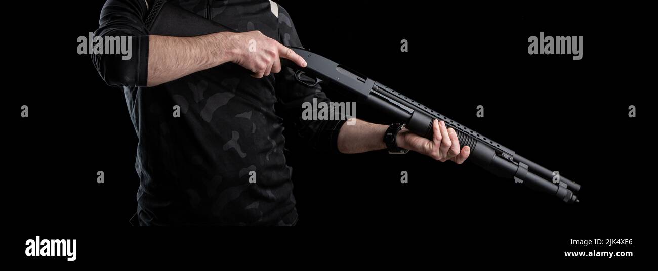 The man is holding a weapon. Pump-action 12 gauge shotgun isolated on a ...