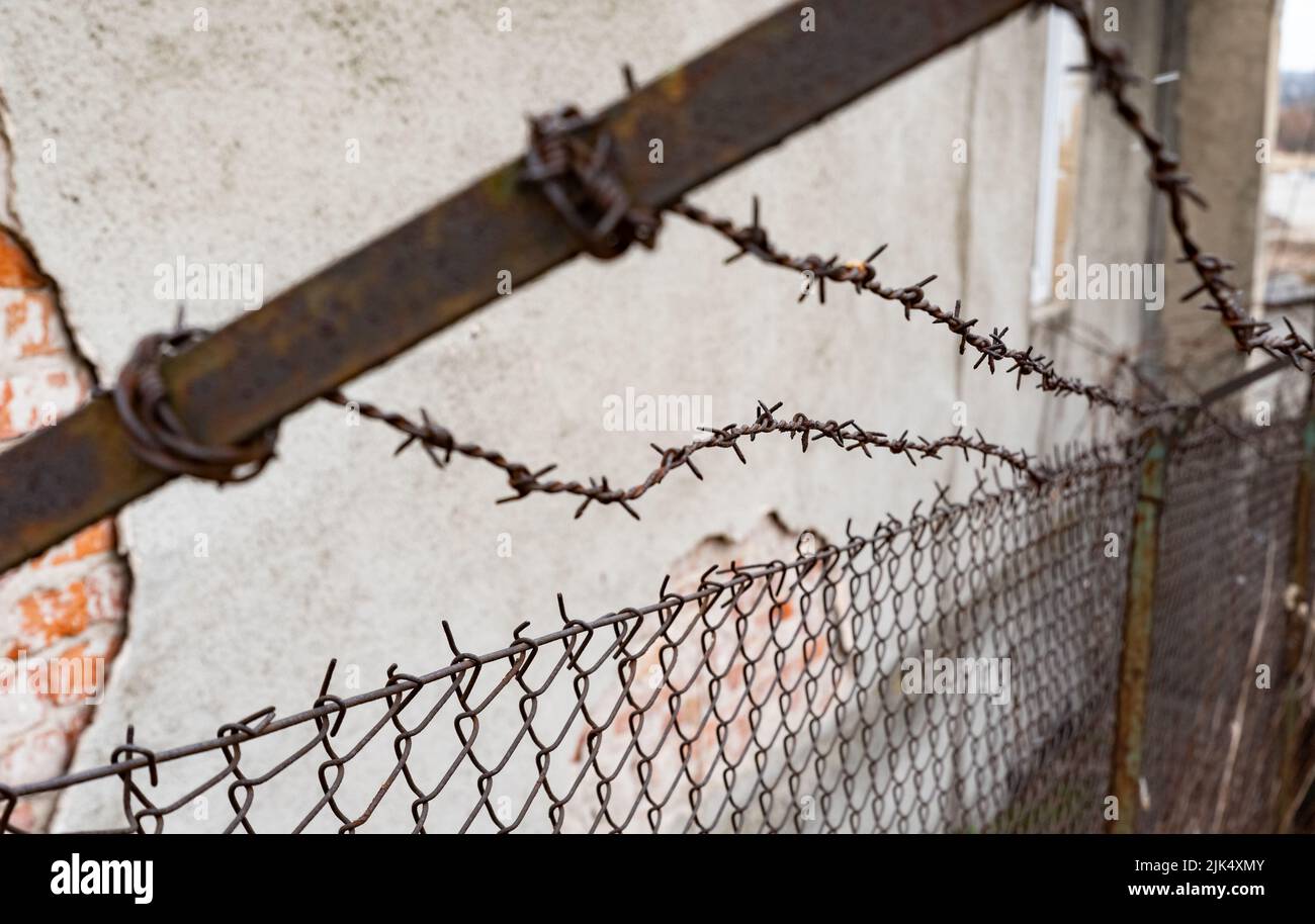 Old barbed wire fence. Rusty barbed wire on a brick wall background ...