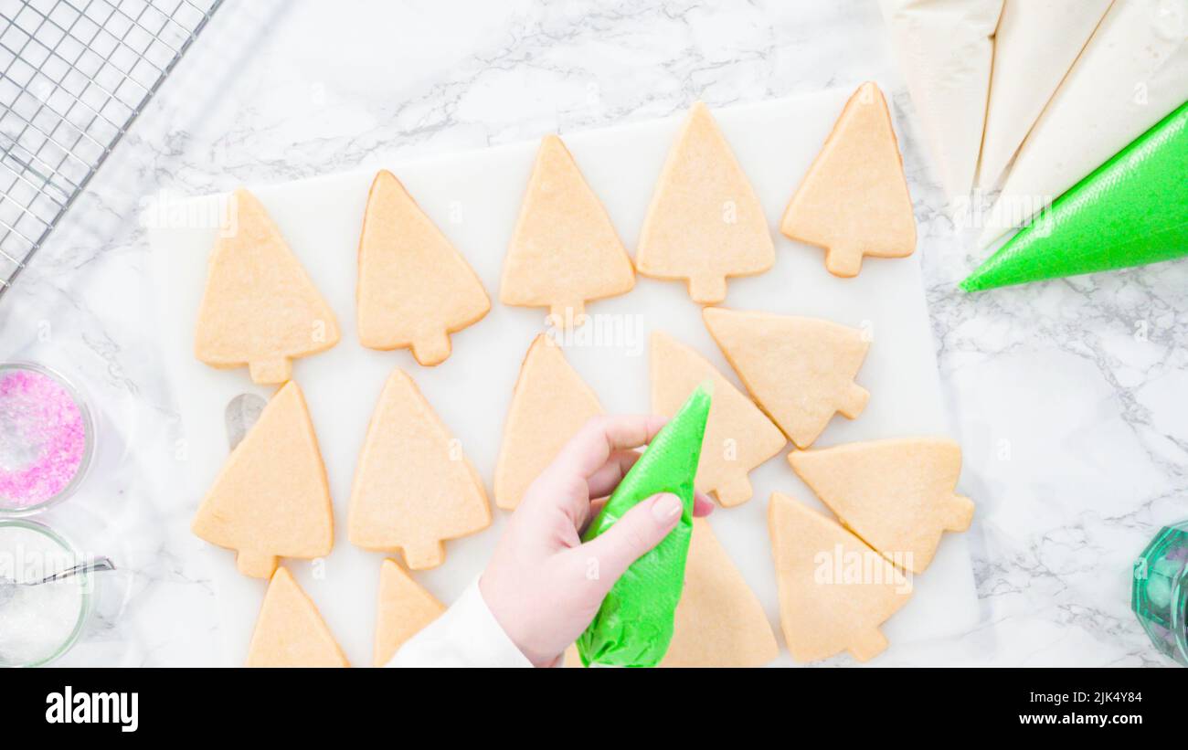 Flat lay. Stp by step. Icing Christmas tree-shaped sugar cookies with ...