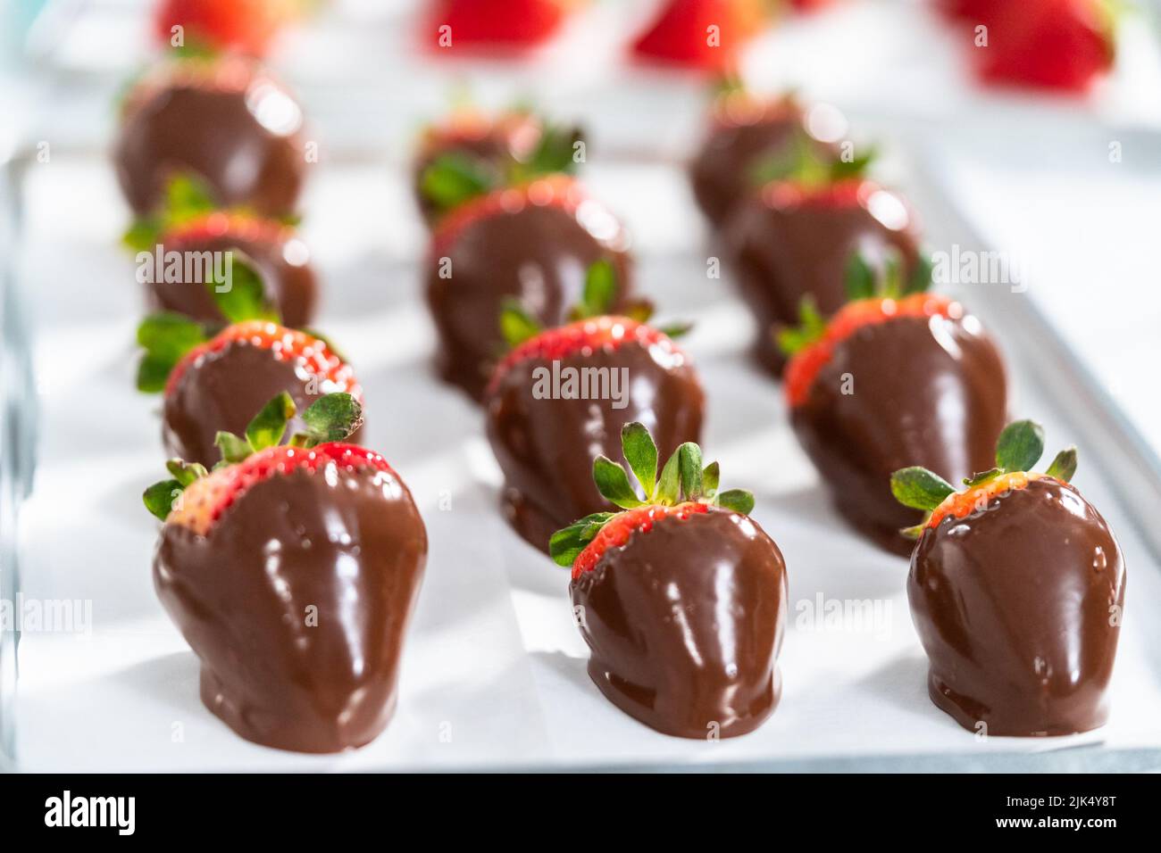 Making white and dark chocolate dipped strawberries Stock Photo - Alamy