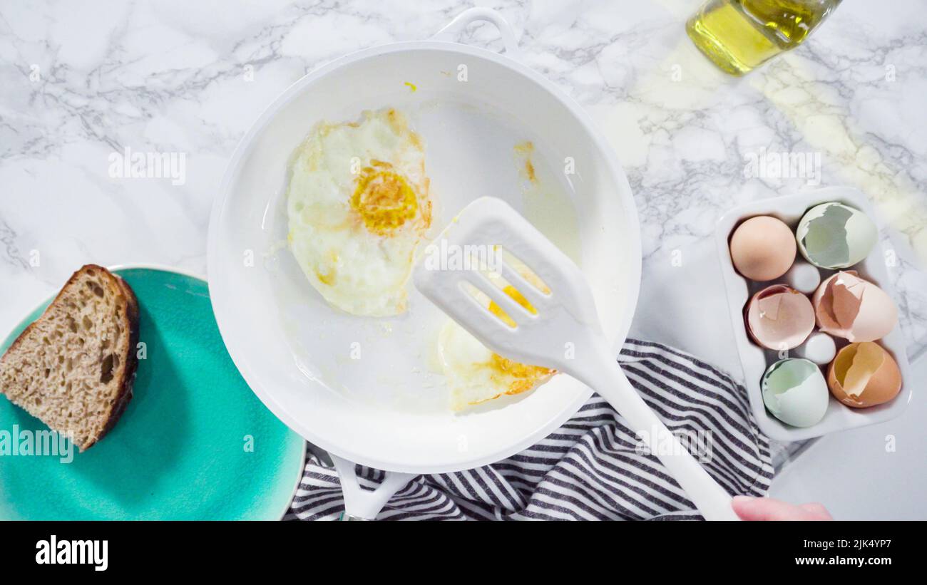 Flat lay. Frying farm fresh eggs in a white skillet Stock Photo - Alamy