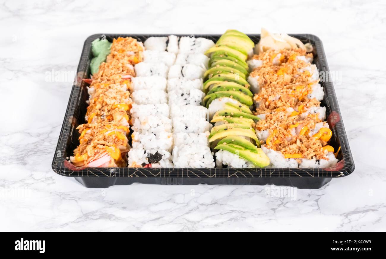 Pre-packaged variety of sushi and sushi rolls in a plastic tray Stock ...