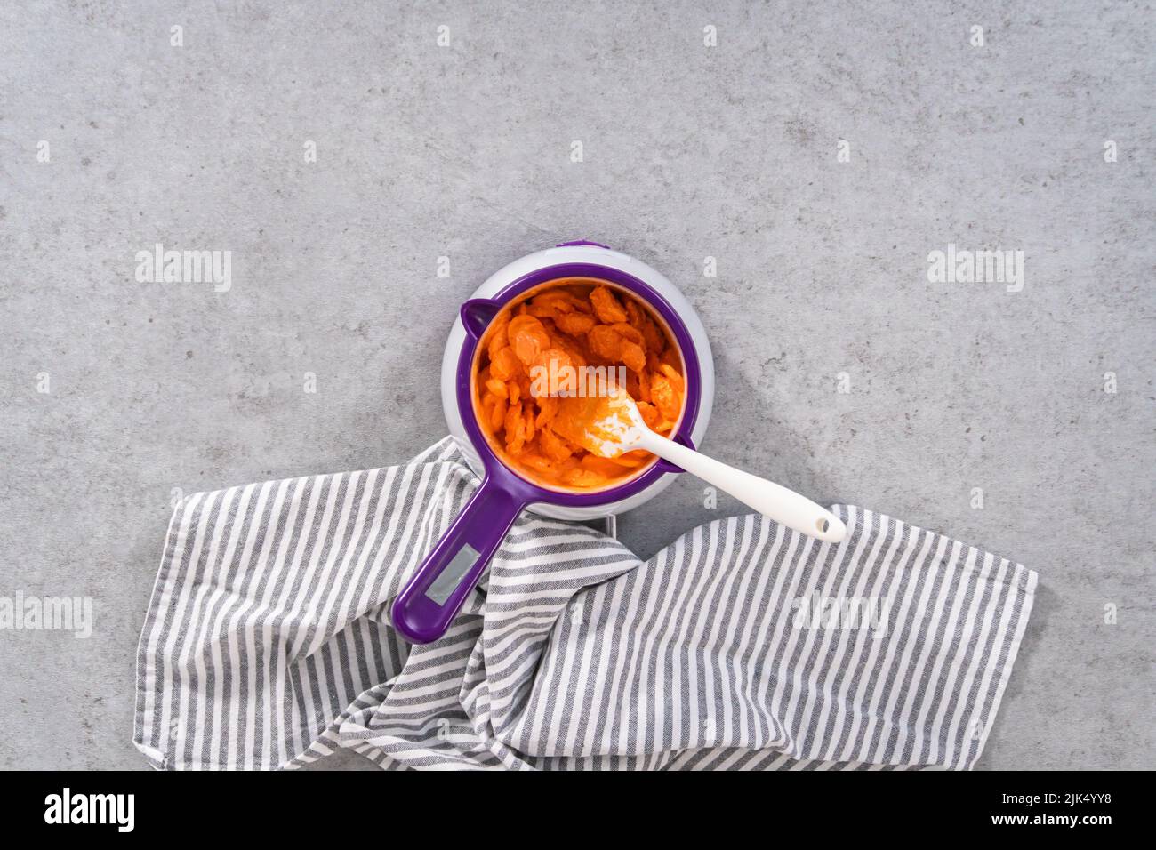 Flat lay. Melting color chocolate chips in a candy melting pot to make ...