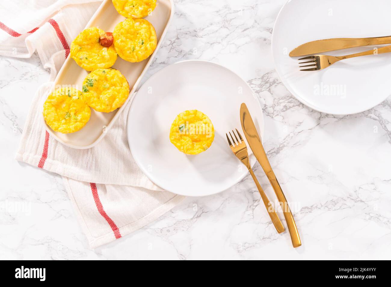 Flat lay. Bacon and cheese egg muffin on a white serving plate Stock ...