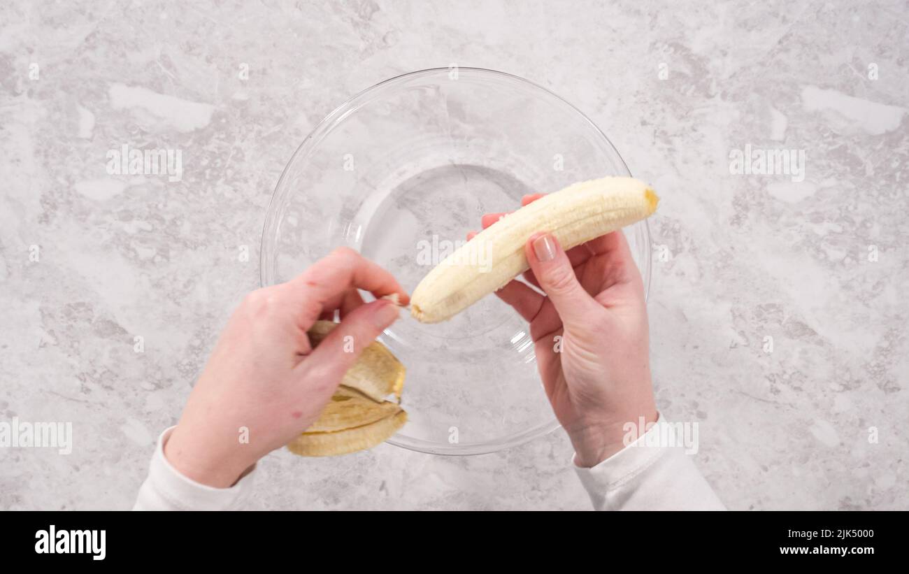 Flat lay. Step by step. Smashing riped bananas in a glass mixing bowl ...