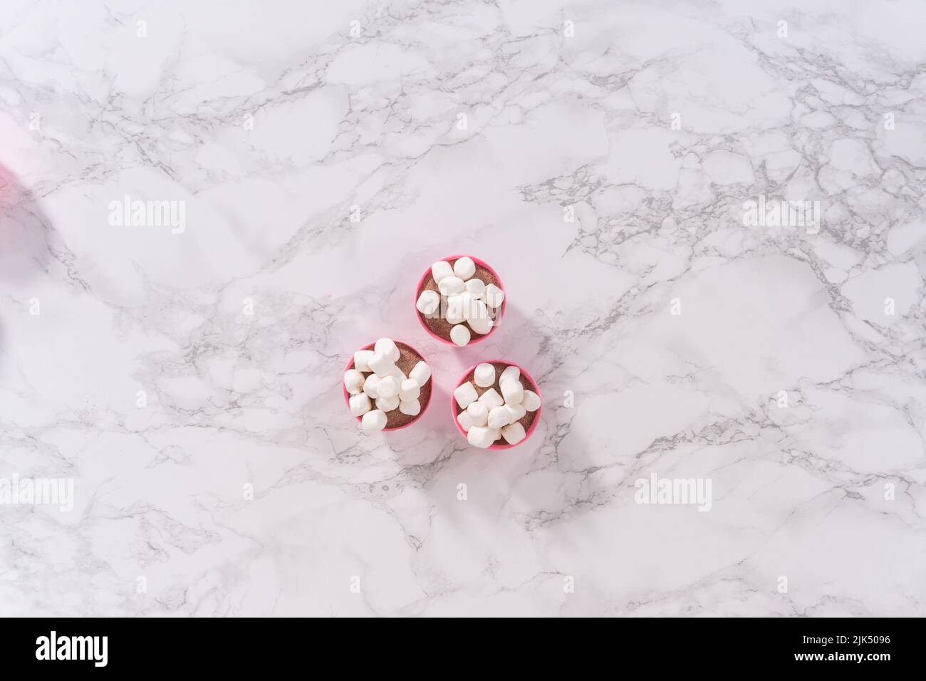 Filling in pink chocolate shells with hot chocolate mix and mini ...