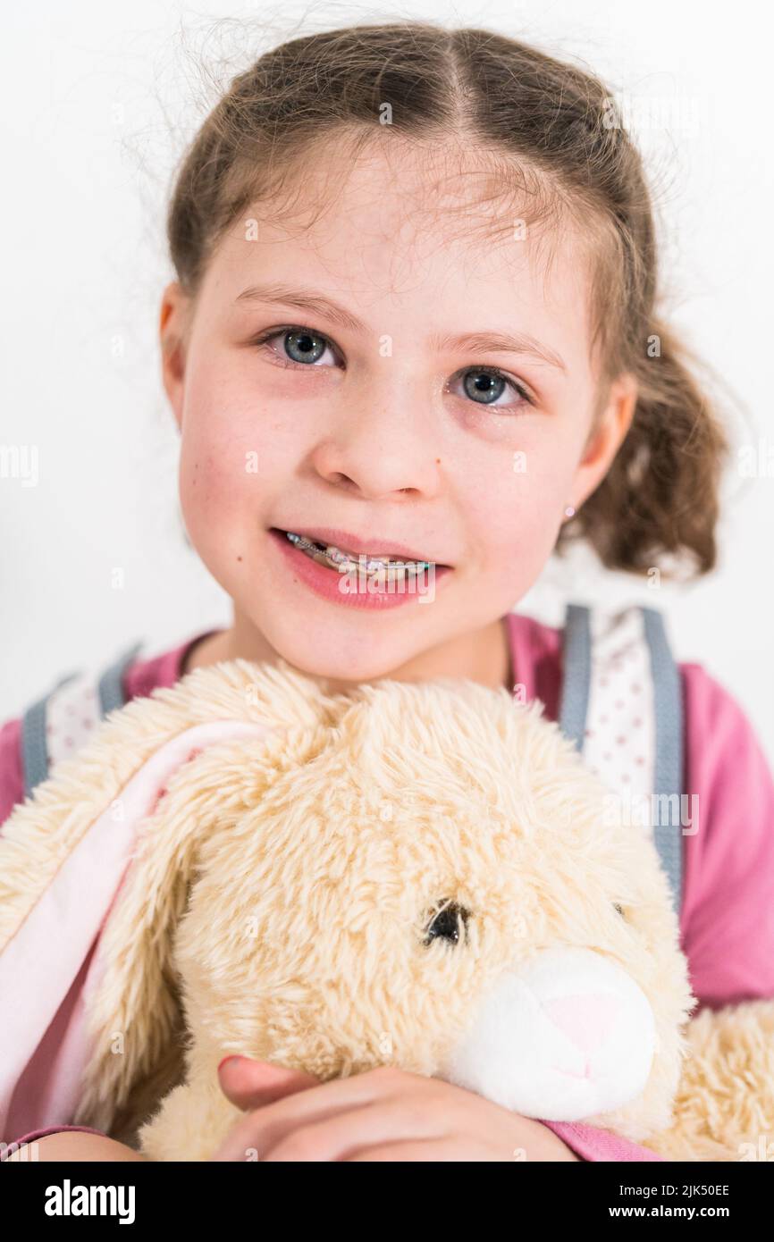 Easter egg coloring. Little girl hugging her big stuffed bunny Stock ...