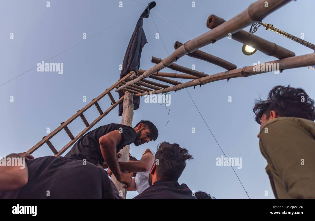 Kashmiri Shia Muslims hoist a religious flag as Muharram starts in ...