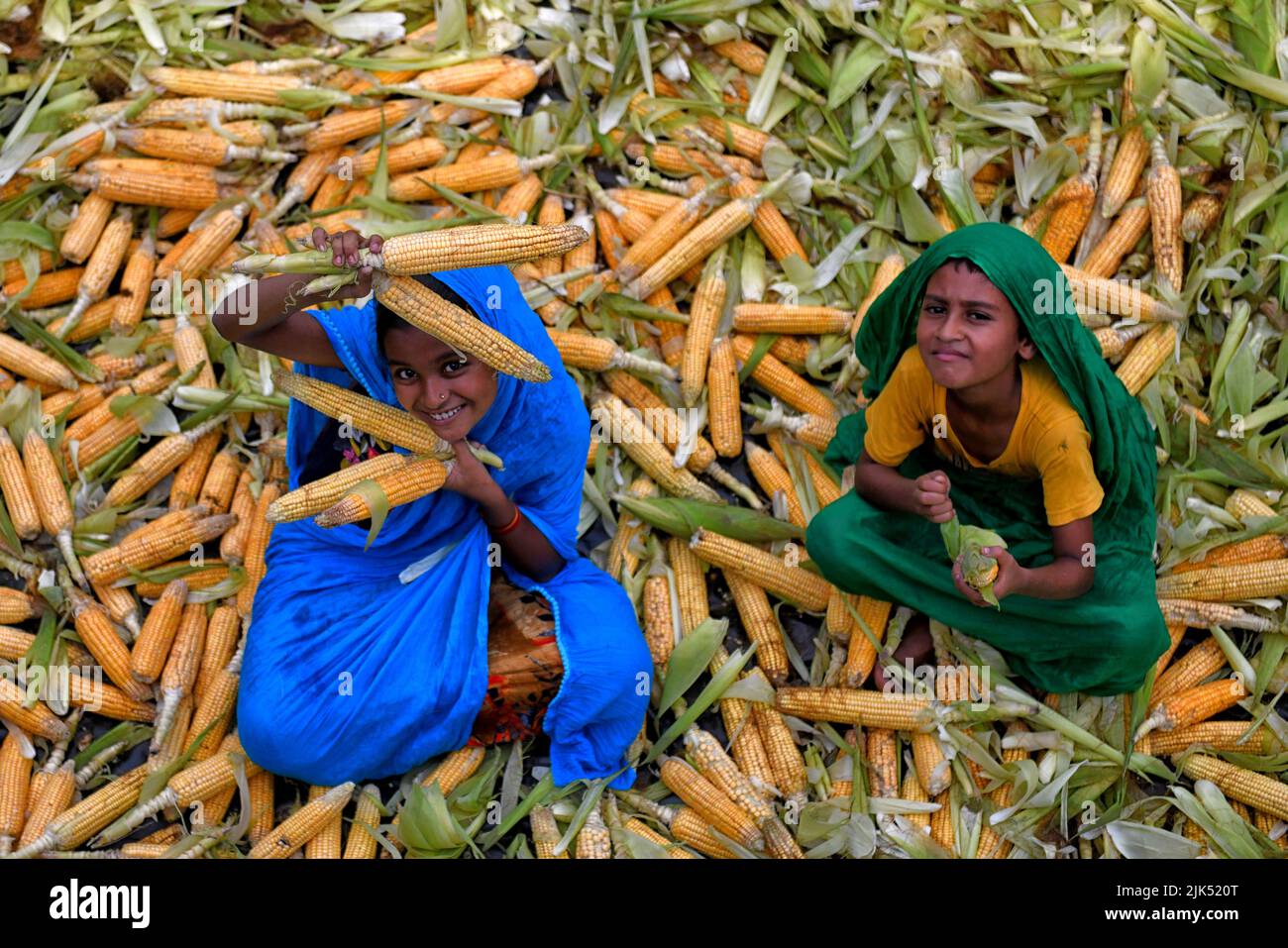 Children pose with maize inside a factory premises. As per the latest ...