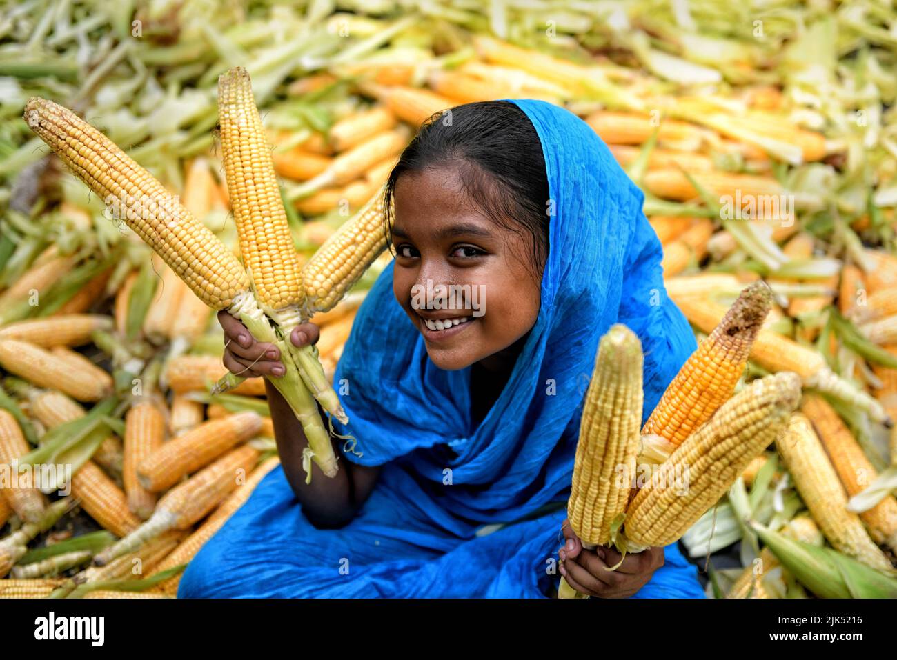 Child poses with maize inside a factory premises. As per the latest ...
